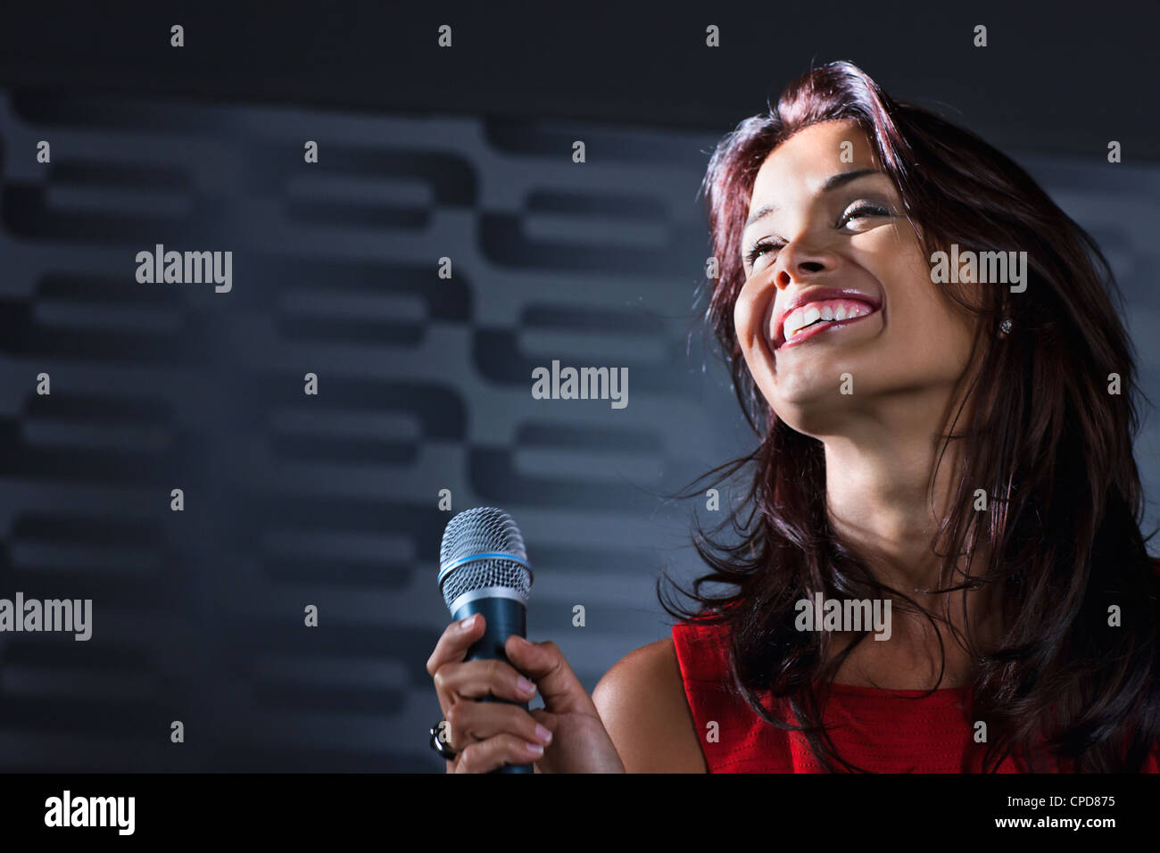 Mixed race woman singing karaoke in nightclub Stock Photo - Alamy