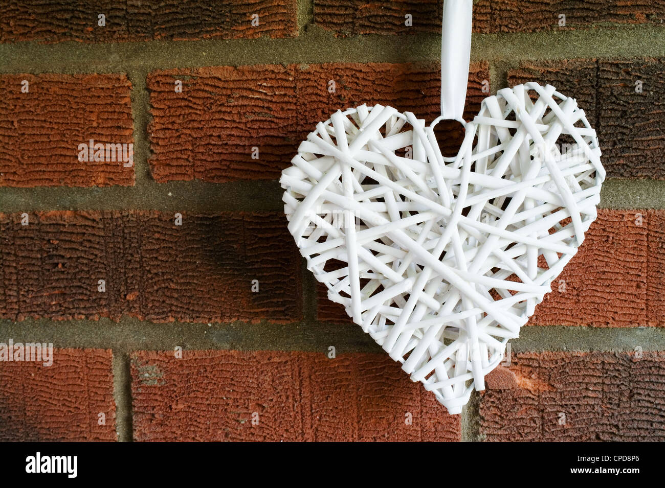 White heart on a brick wall background Stock Photo - Alamy