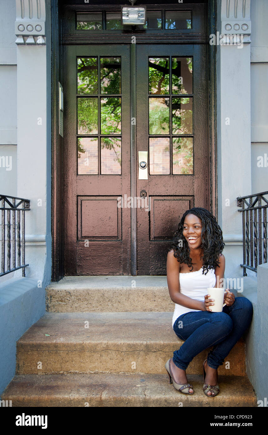 Woman sitting on stoop drinking hi-res stock photography and images - Alamy