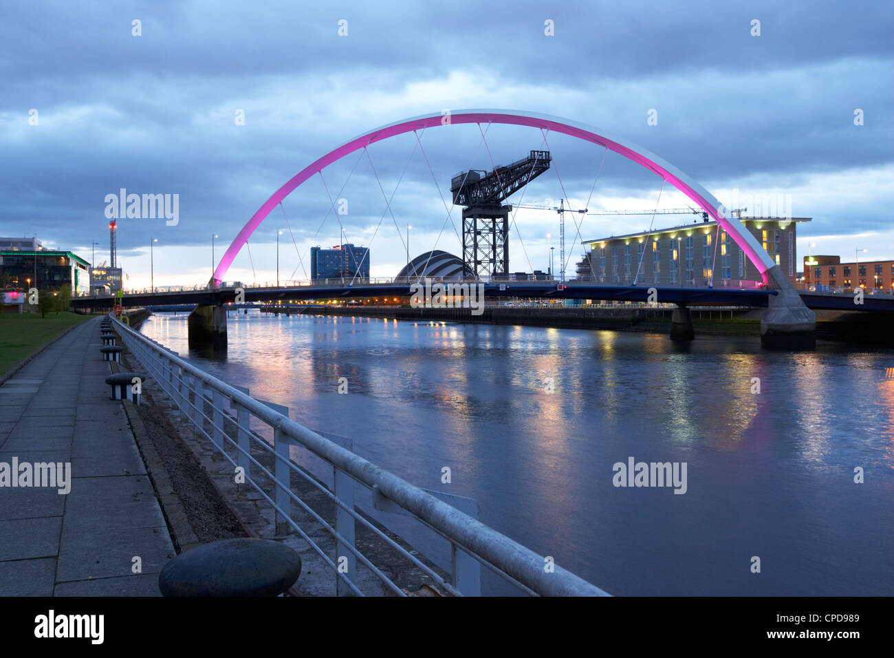 riverside walkway by the Clyde Arc bridge over the river clyde at dusk ...