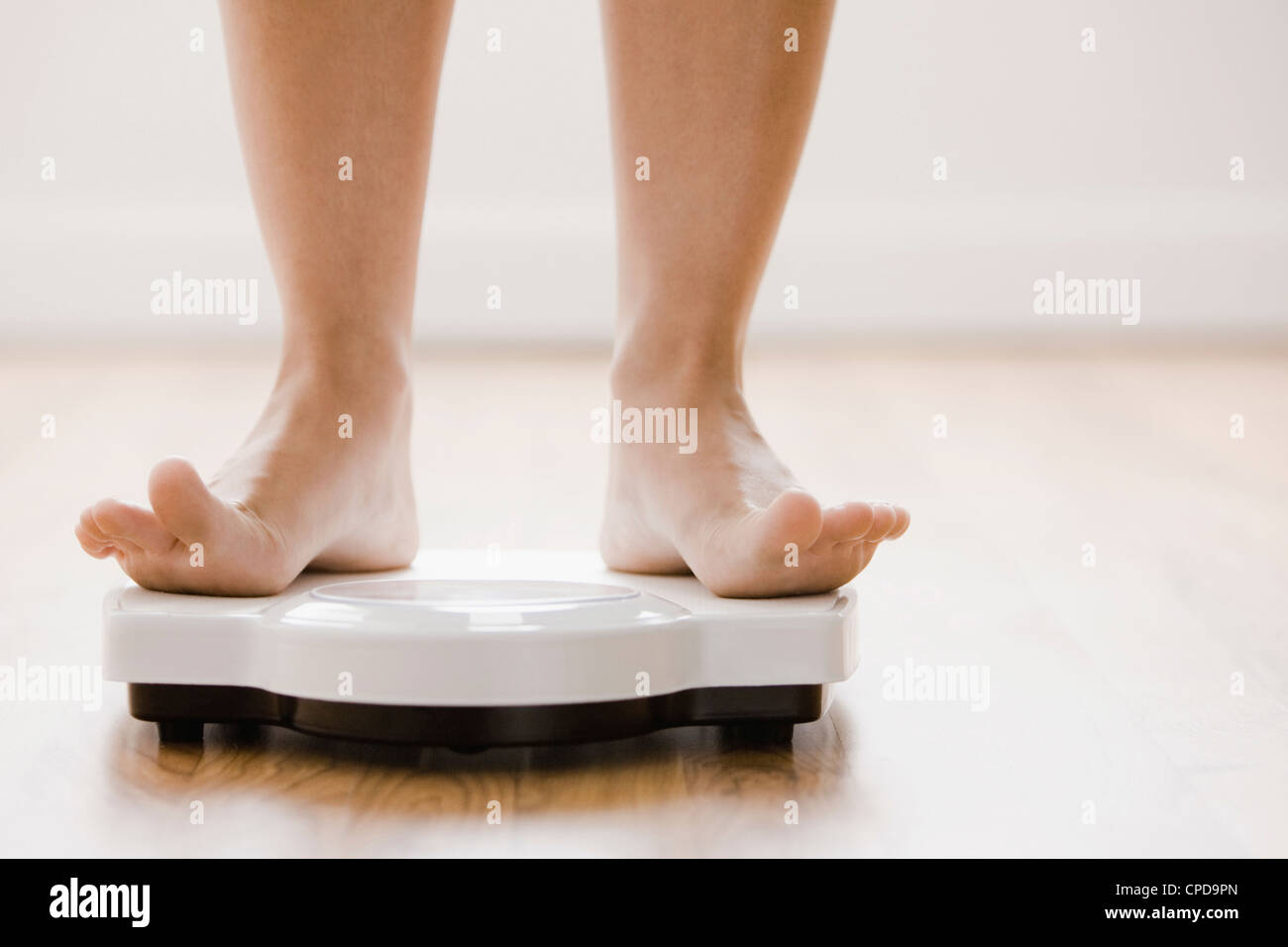 Caucasian woman's feet standing on scale Stock Photo - Alamy