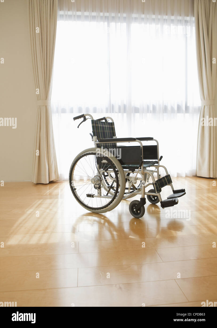 Wheelchair by a window Stock Photo - Alamy