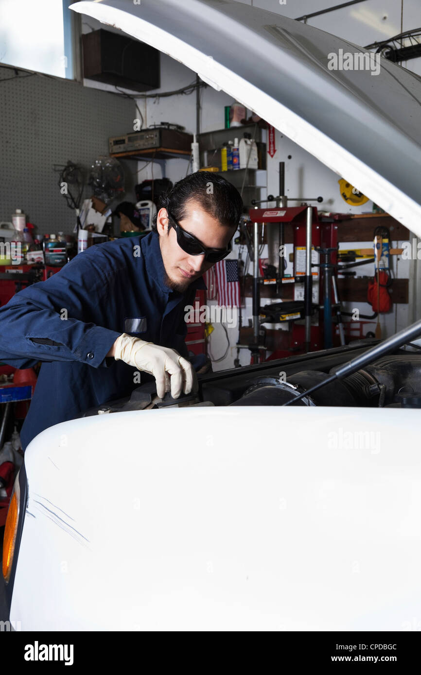 Hispanic mechanic working on car Stock Photo - Alamy