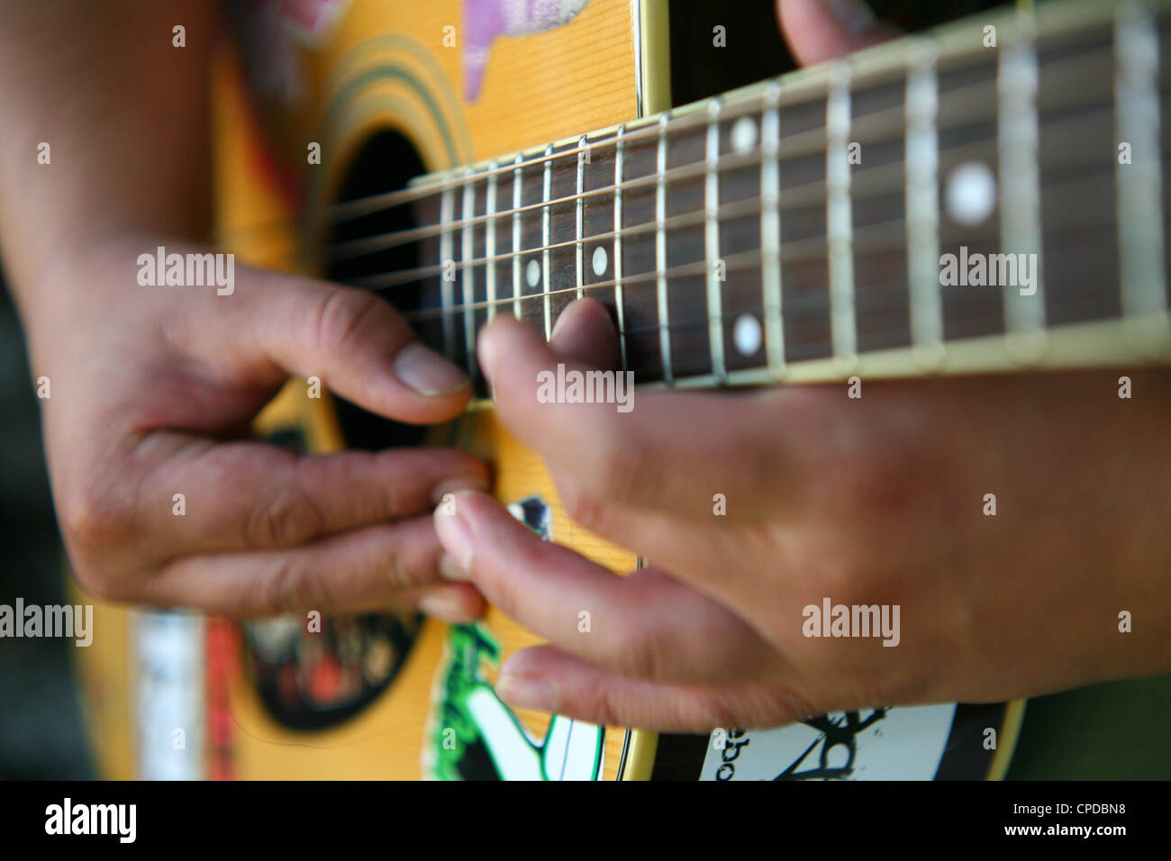Ethnic hands playing an acoustic guitar Stock Photo - Alamy