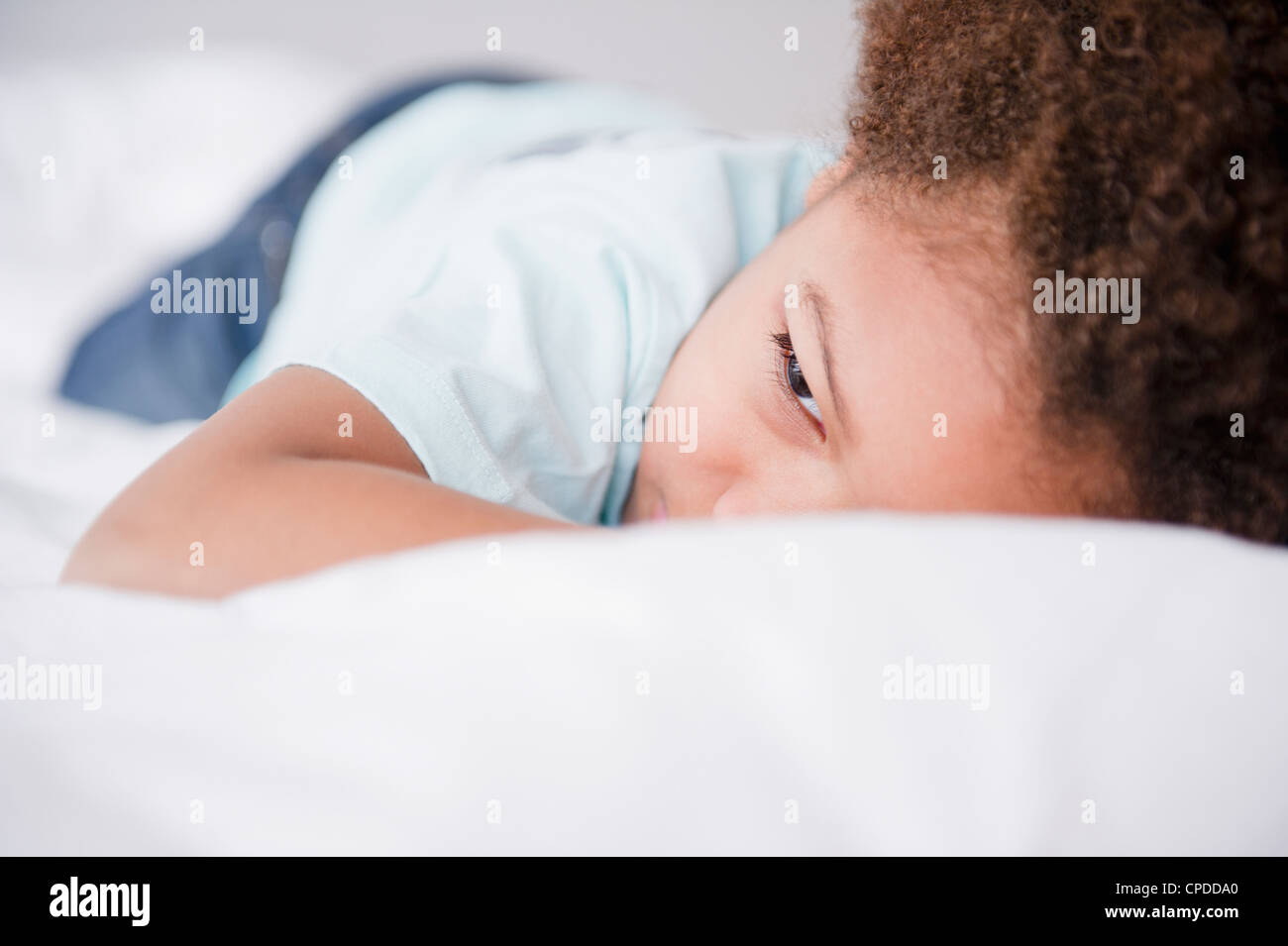 Black boy laying on bed Stock Photo - Alamy