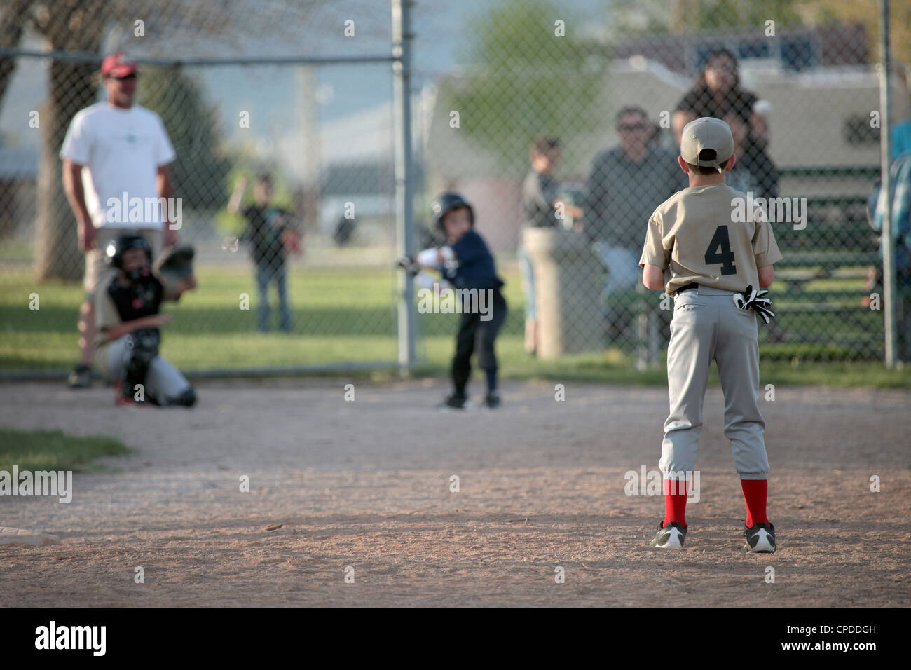 Little league baseball team players boy hits ball and runs to first ...