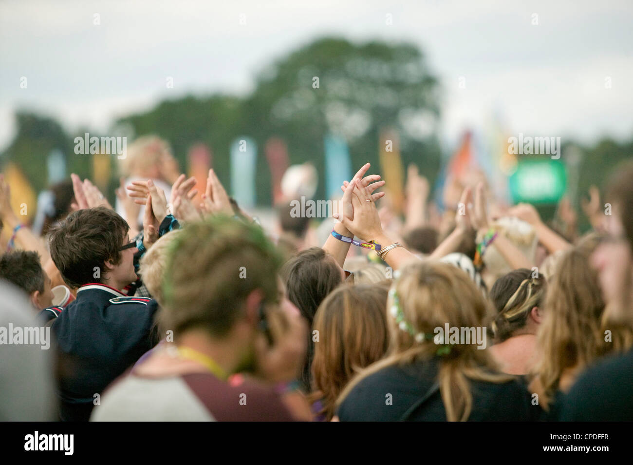 Girl at a music festival on shoulders in the crowd cheering Stock Photo ...