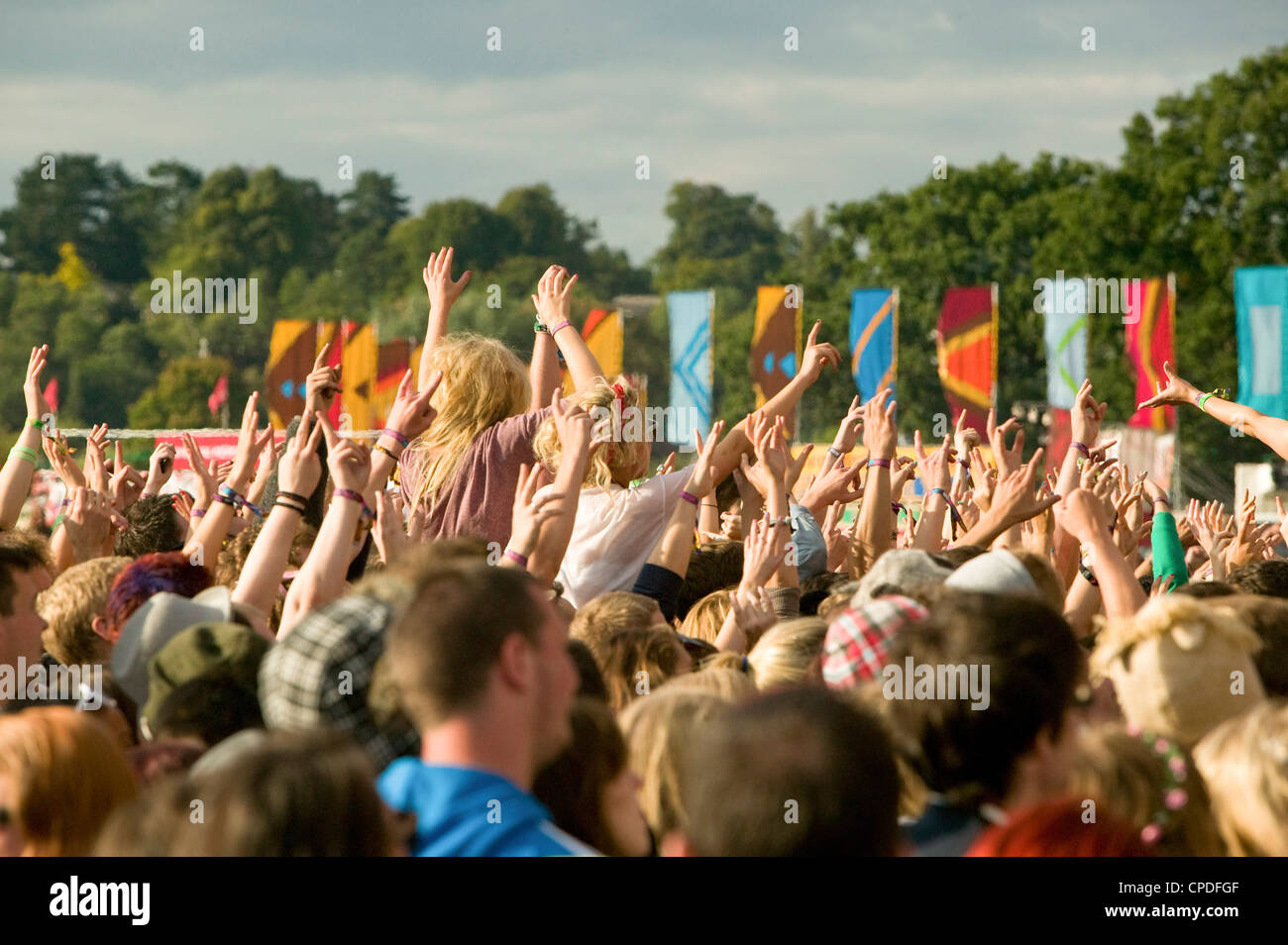 Girl at a music festival on shoulders in the crowd cheering Stock Photo ...