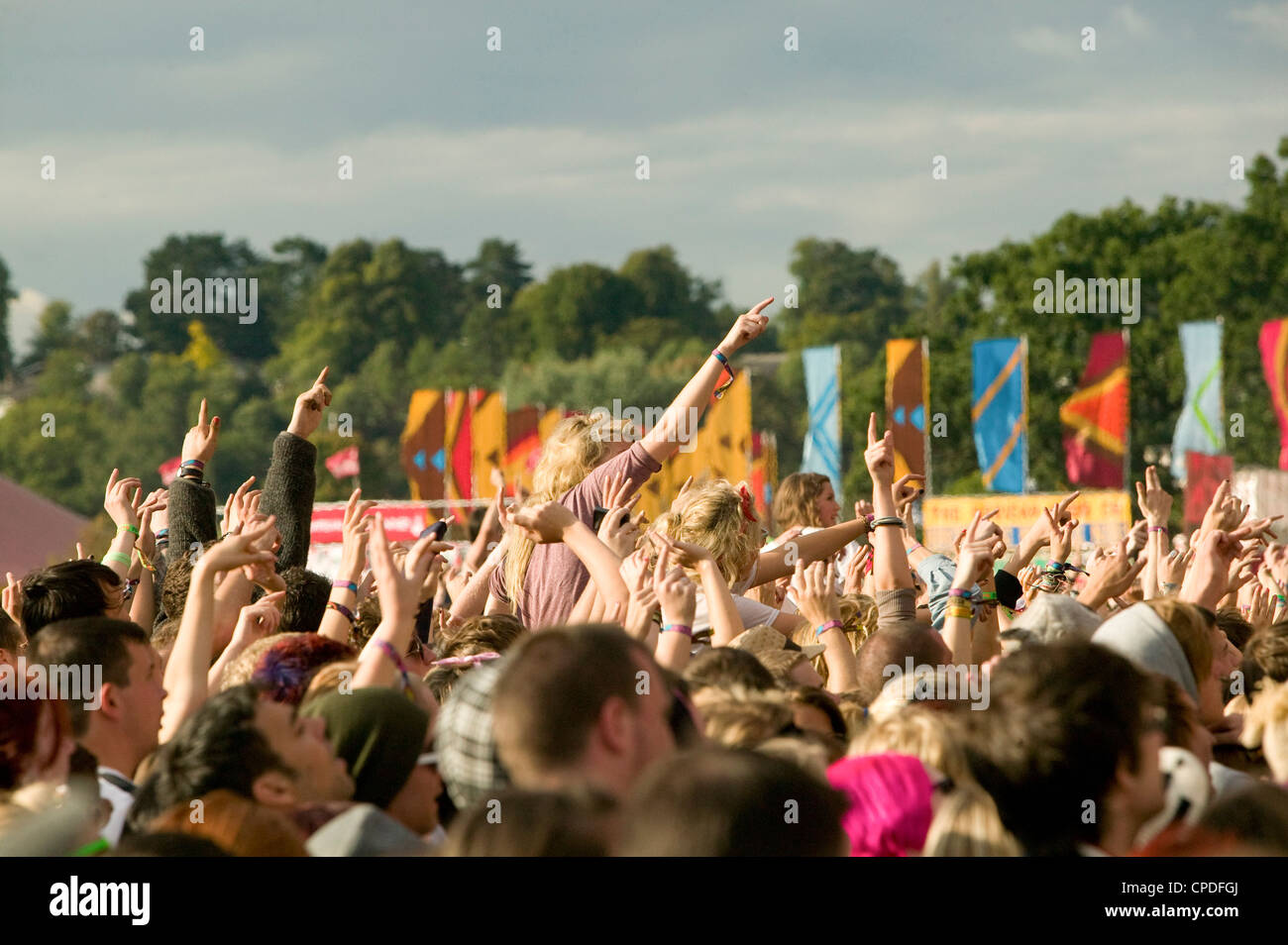 Girl at a music festival on shoulders in the crowd cheering Stock Photo ...
