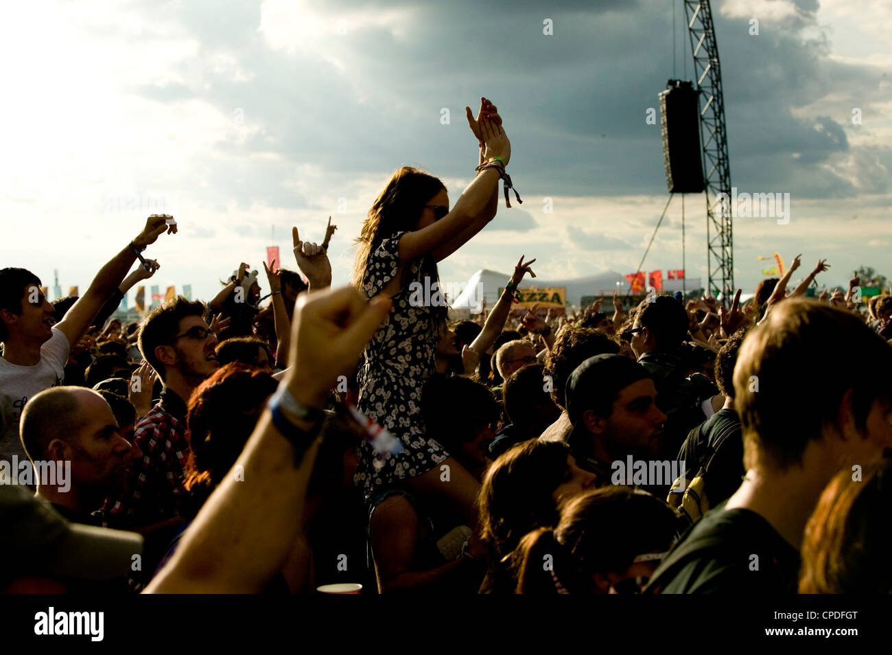 Girl at a music festival on shoulders in the crowd cheering Stock Photo ...