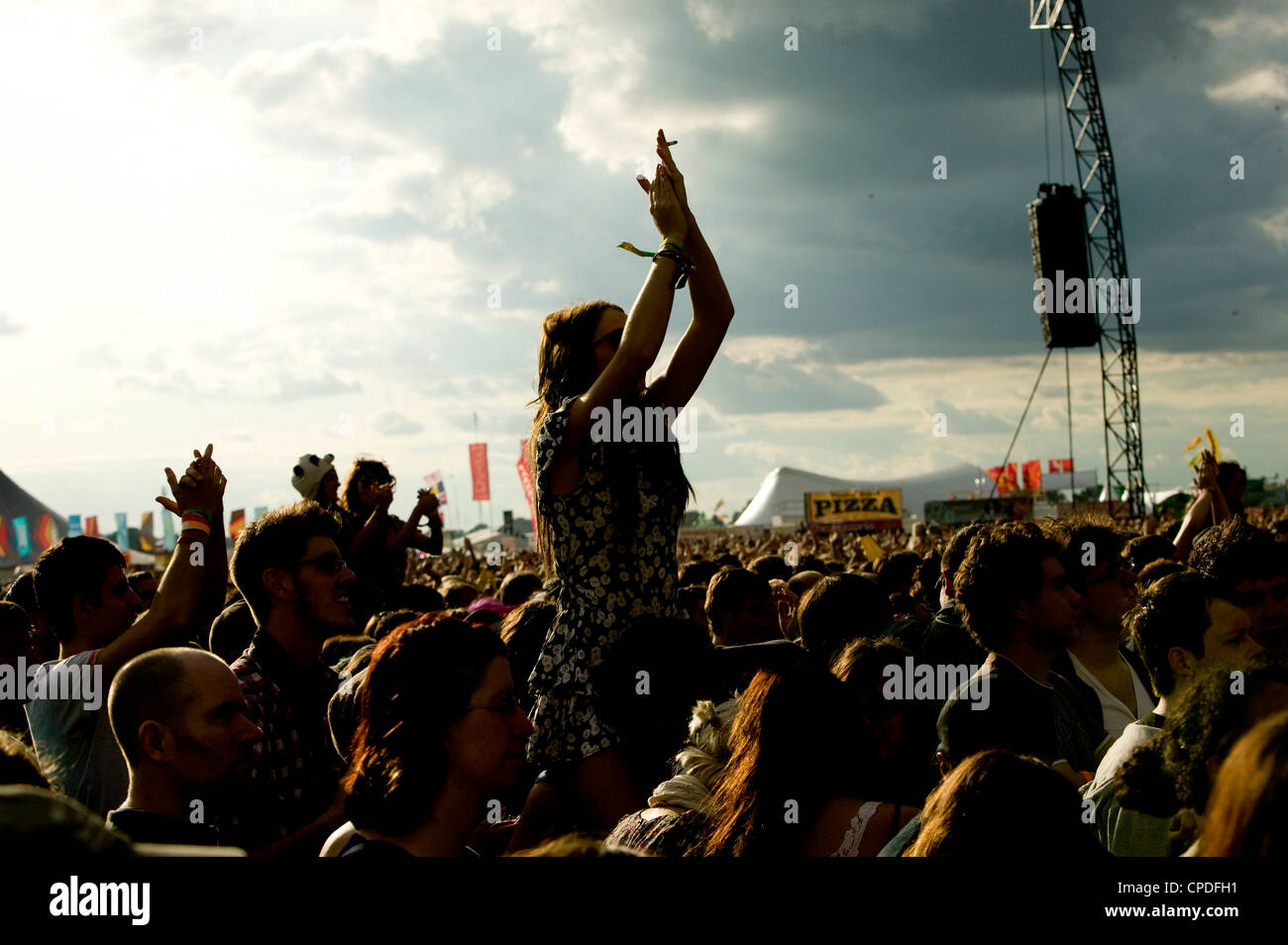 Girl at a music festival on shoulders in the crowd cheering Stock Photo ...