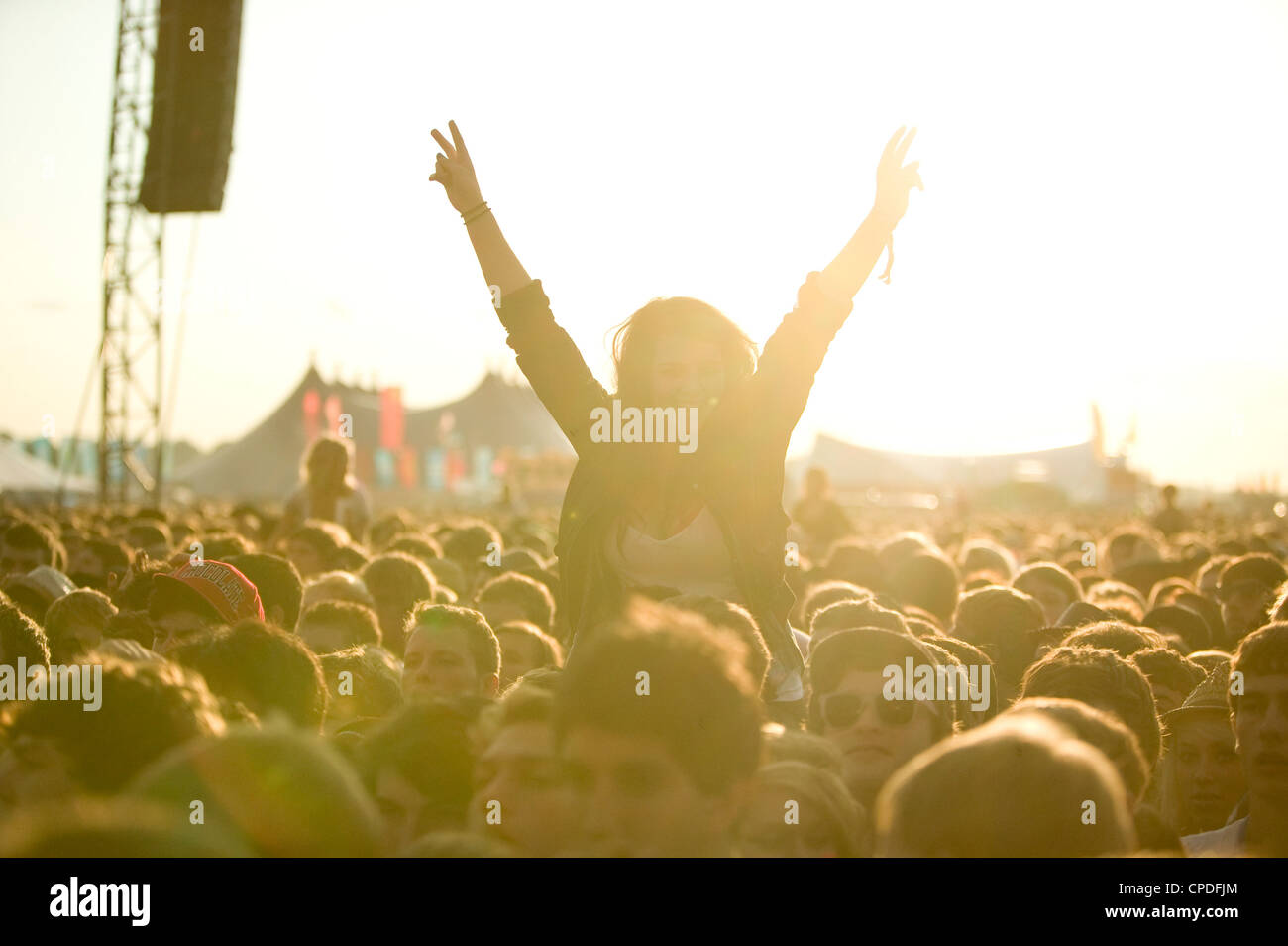 Girl at a music festival on shoulders in the crowd cheering Stock Photo ...