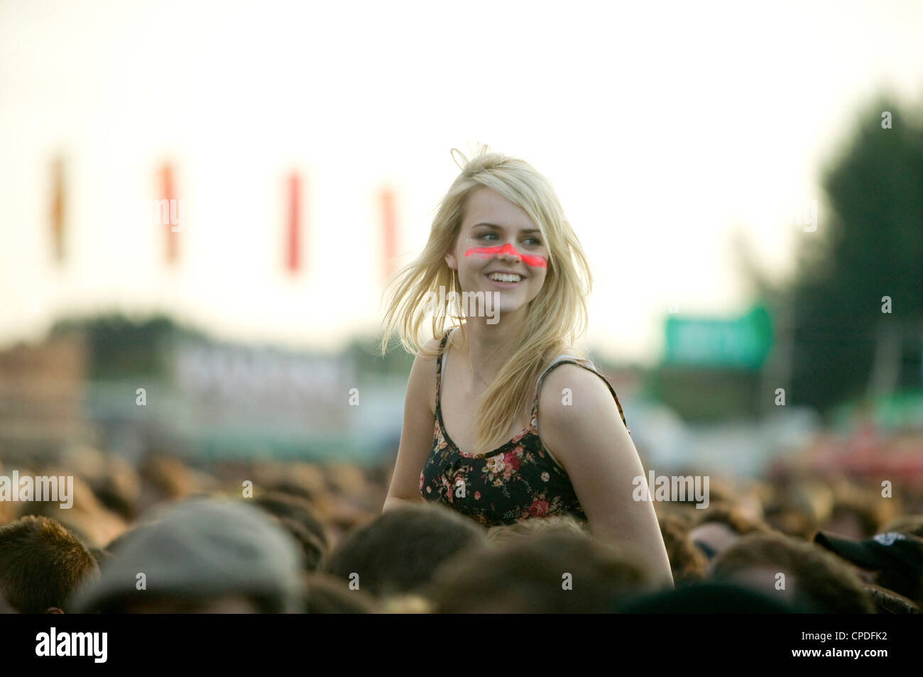 Girl at a music festival on shoulders in the crowd cheering Stock Photo ...