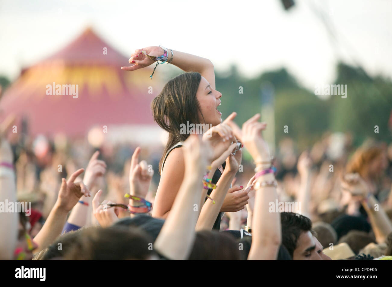 Girl at a music festival on shoulders in the crowd cheering Stock Photo ...