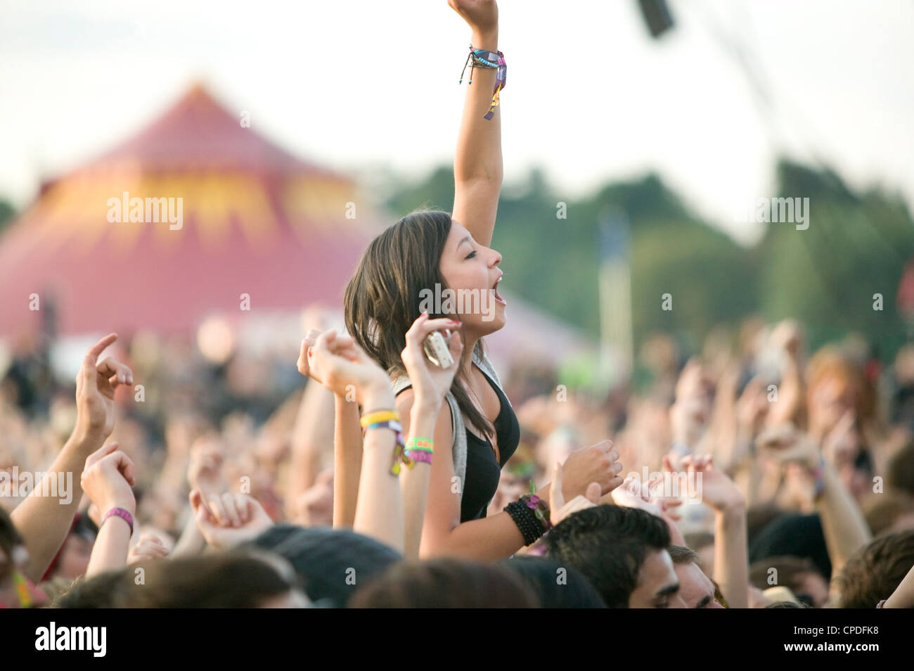 Girl at a music festival on shoulders in the crowd cheering Stock Photo ...