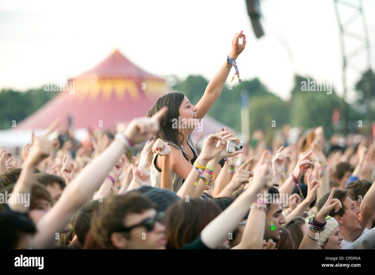 Girl at a music festival on shoulders in the crowd cheering Stock Photo ...