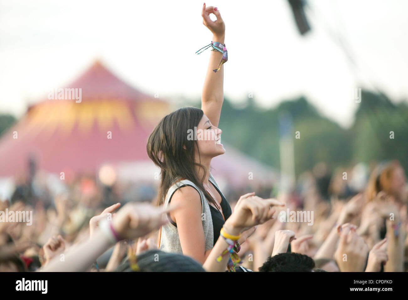 Girl at a music festival on shoulders in the crowd cheering Stock Photo ...