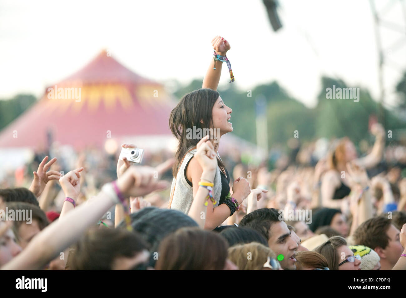 Girl at a music festival on shoulders in the crowd cheering Stock Photo ...