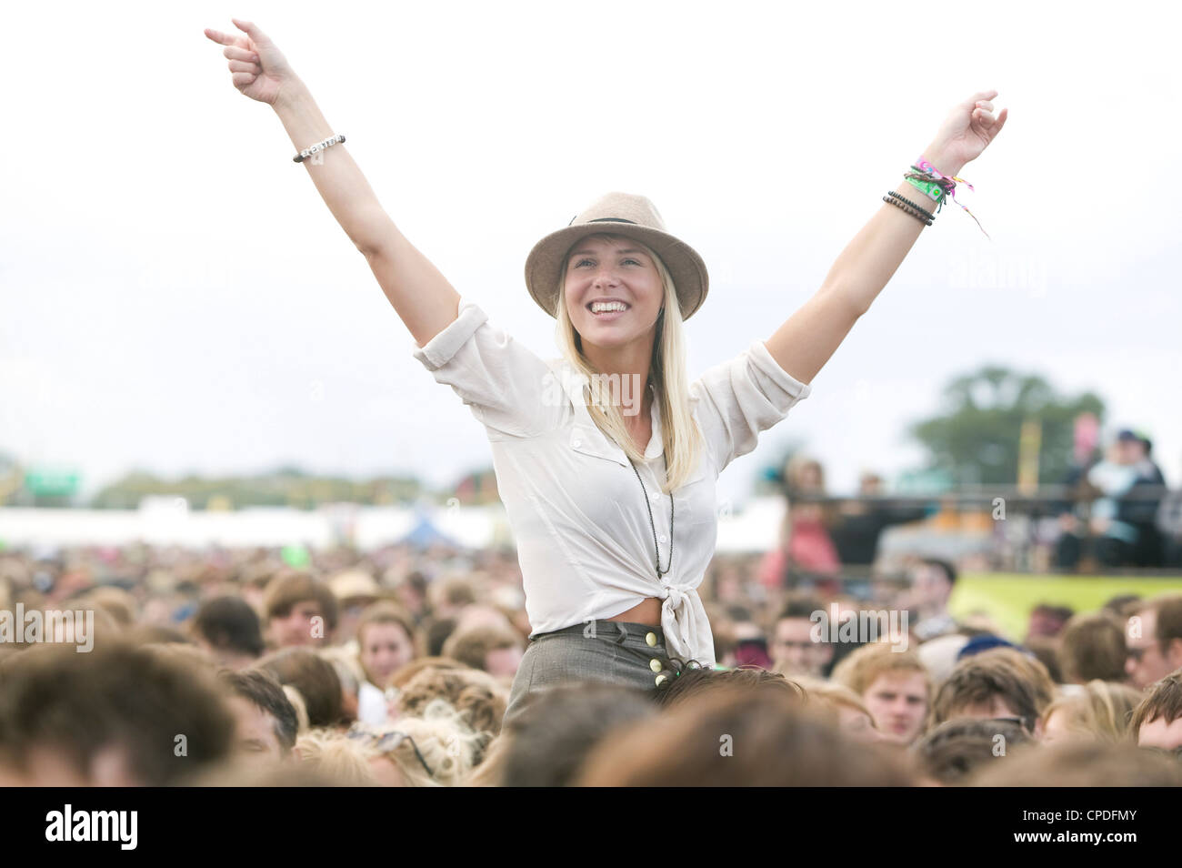 Girl at a music festival on shoulders in the crowd cheering Stock Photo ...