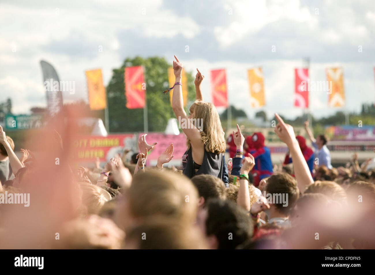Girl at a music festival on shoulders in the crowd cheering Stock Photo ...
