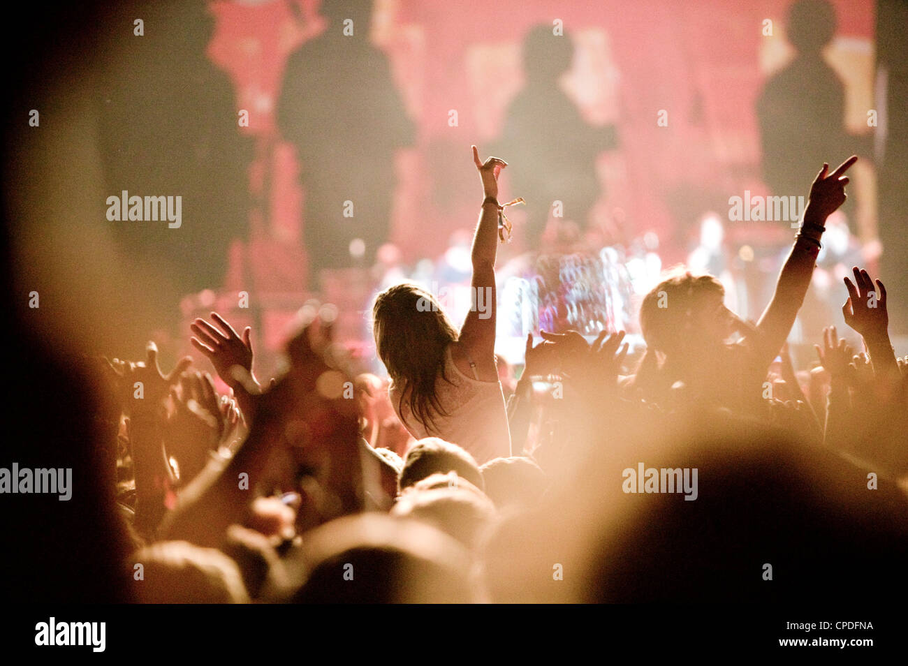 Girl at a music festival on shoulders in the crowd cheering Stock Photo ...