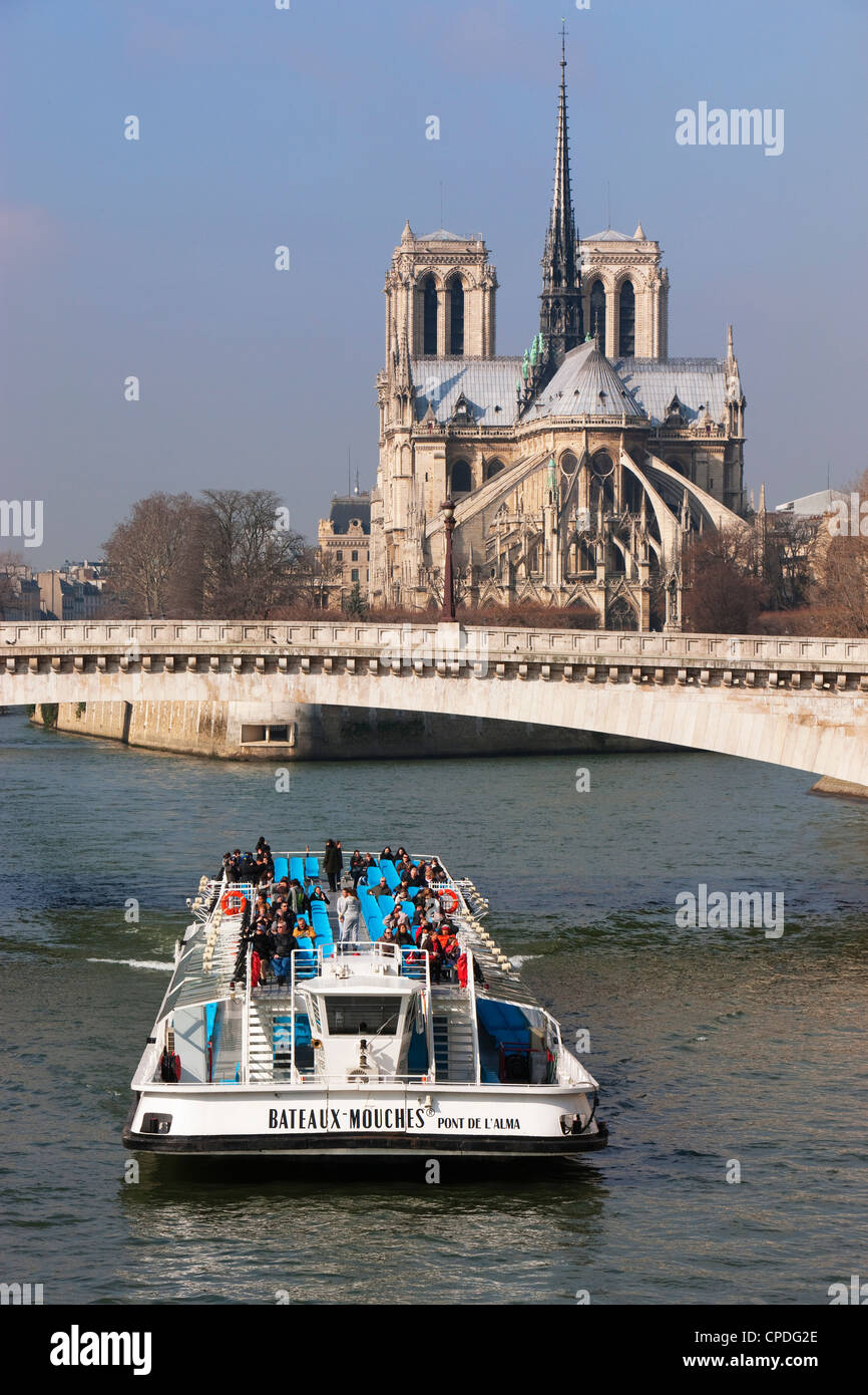 Tourist boat going under bridge on the River Seine, with Notre Dame ...