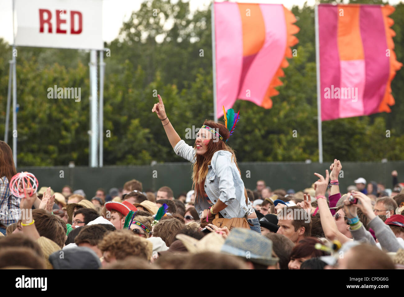 Girl at a music festival on shoulders in the crowd cheering Stock Photo ...