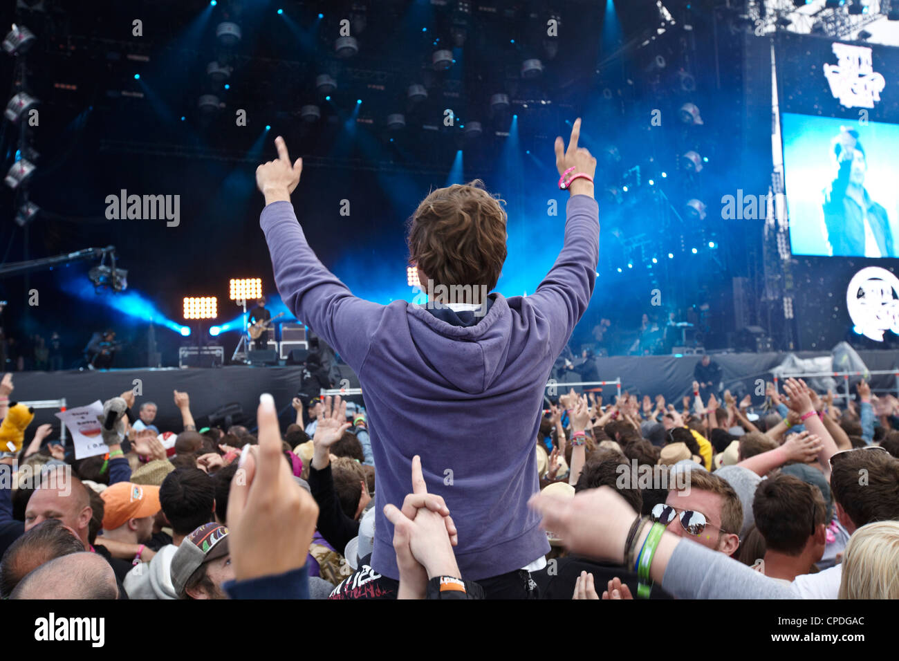 Boy on shoulders cheering in the crowd at gig at a music festival Stock ...