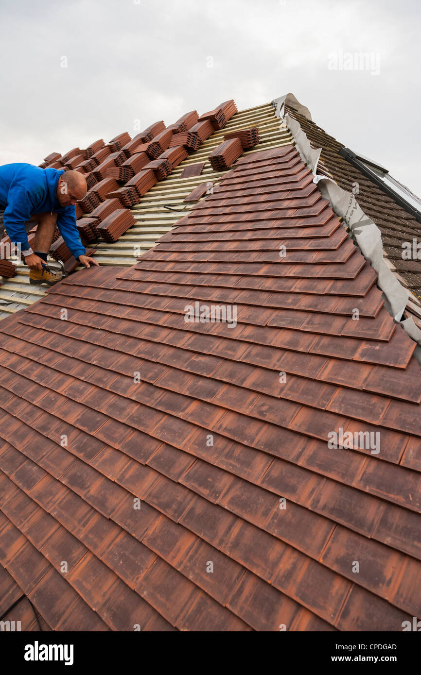 Detached house having tiles striped from roof and replacing with new ...