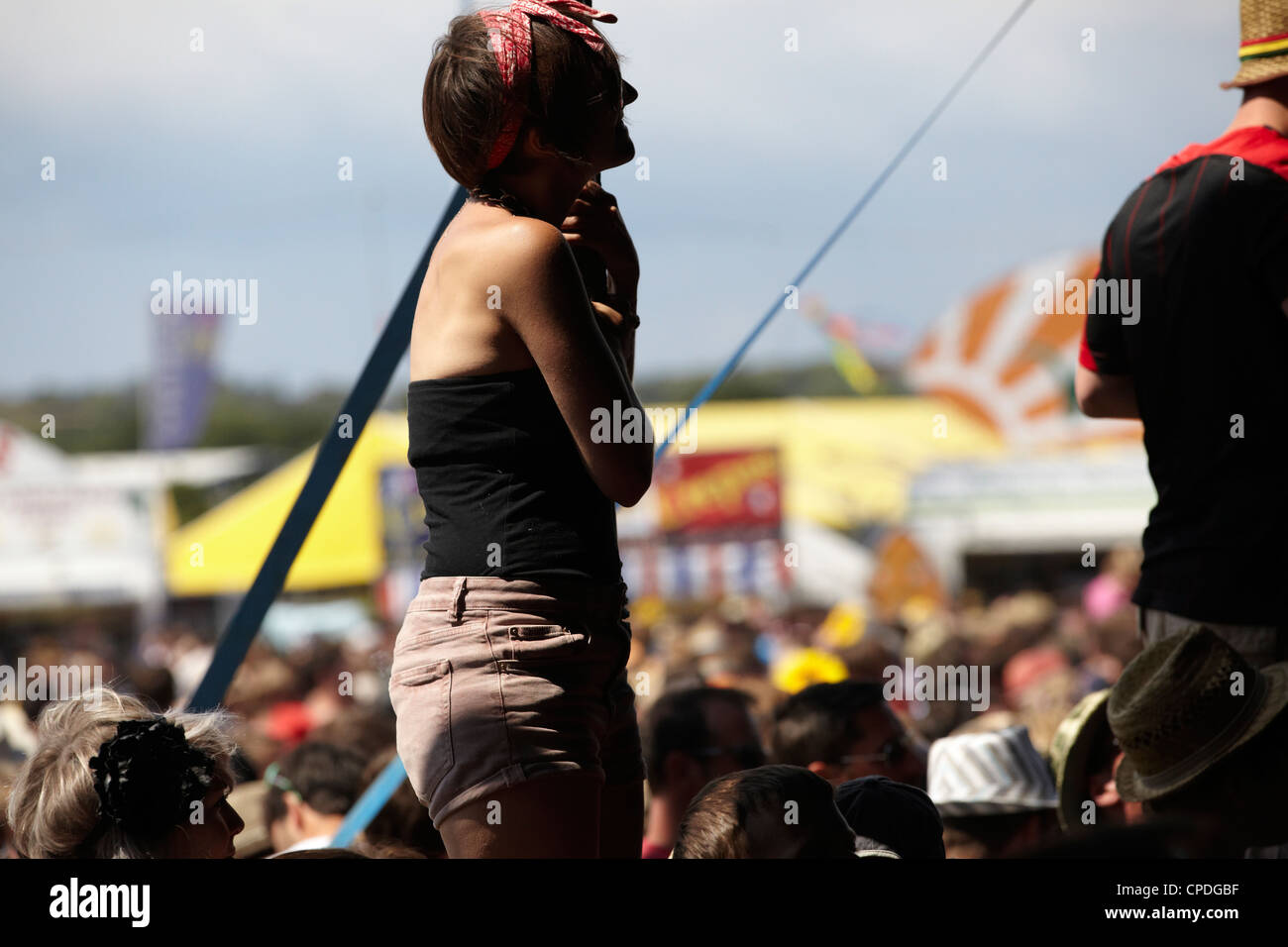 Girl on shoulders cheering in the crowd at gig at a music festival ...