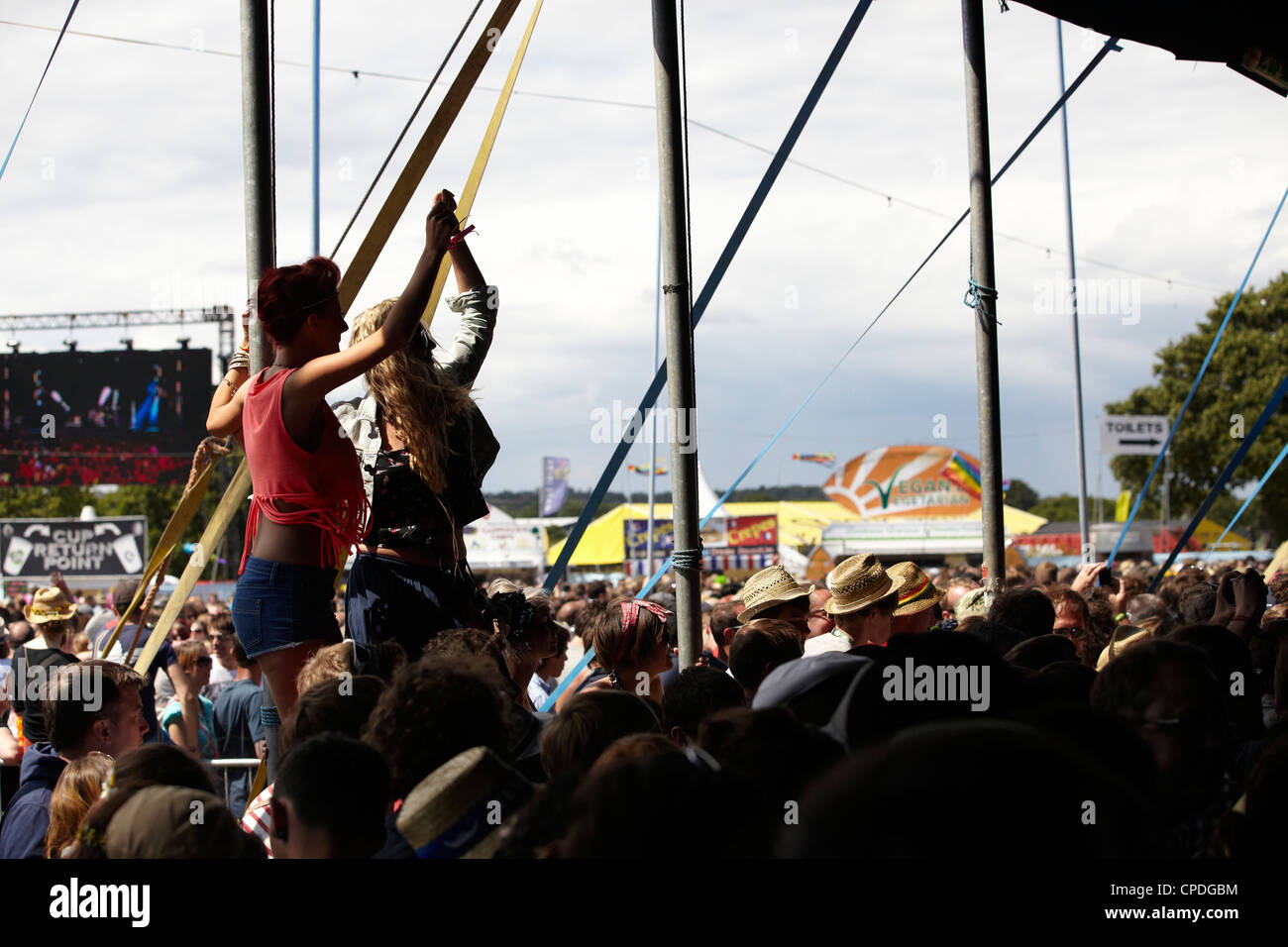 Girl on shoulders cheering in the crowd at gig at a music festival ...