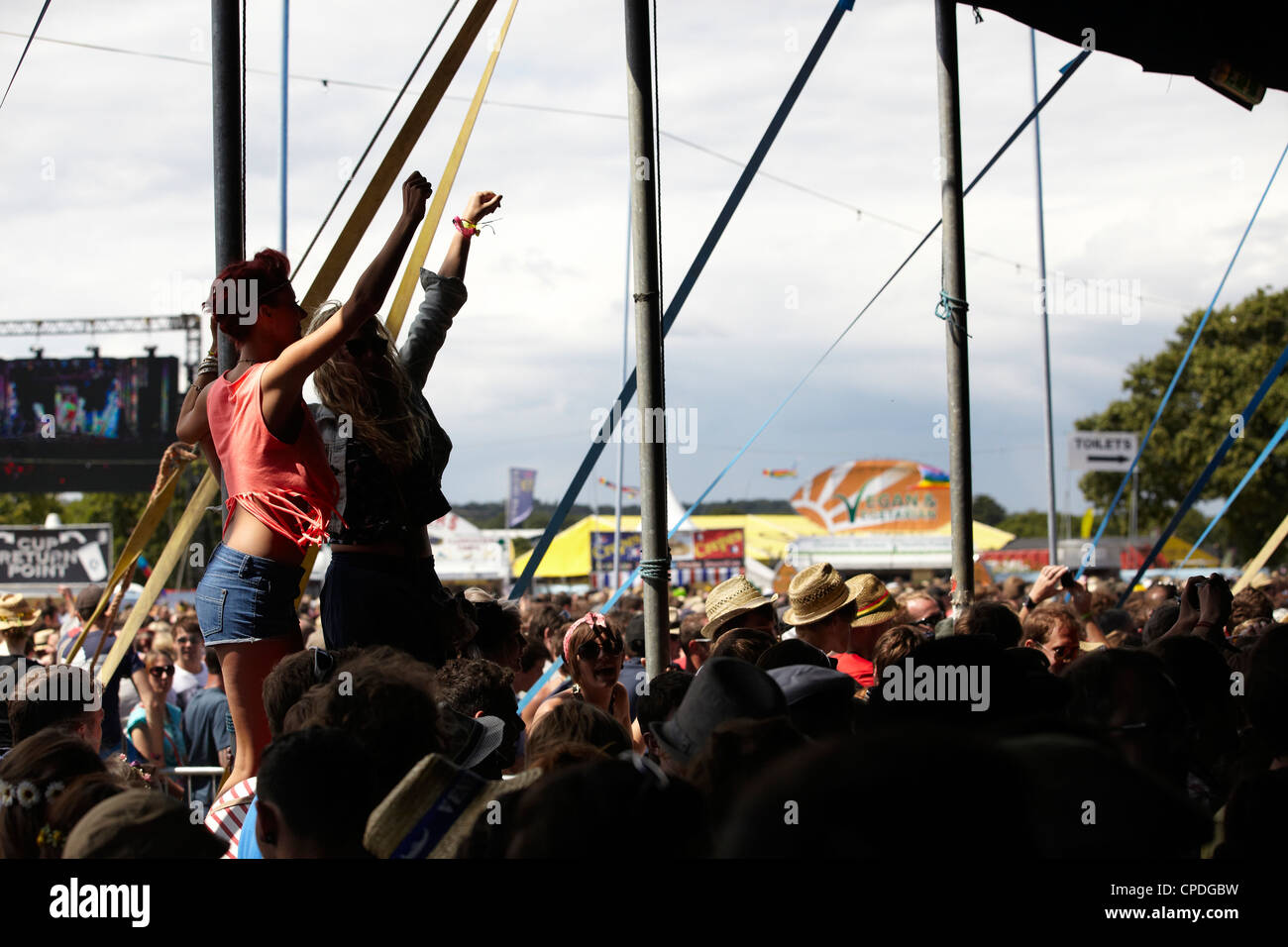 Girl on shoulders cheering in the crowd at gig at a music festival ...