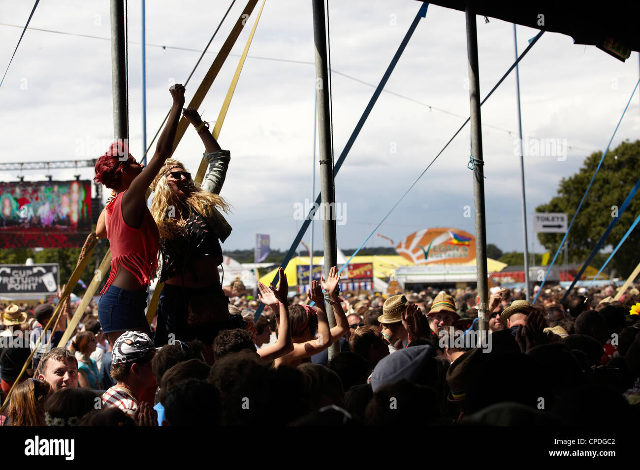 Girl on shoulders cheering in the crowd at gig at a music festival ...