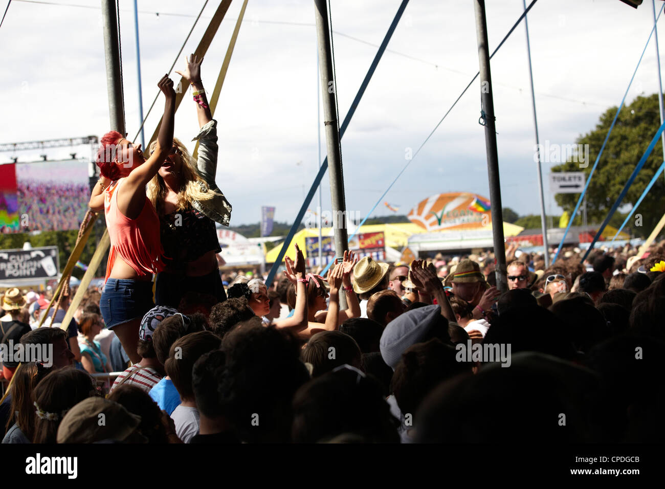 Girl on shoulders cheering in the crowd at gig at a music festival ...
