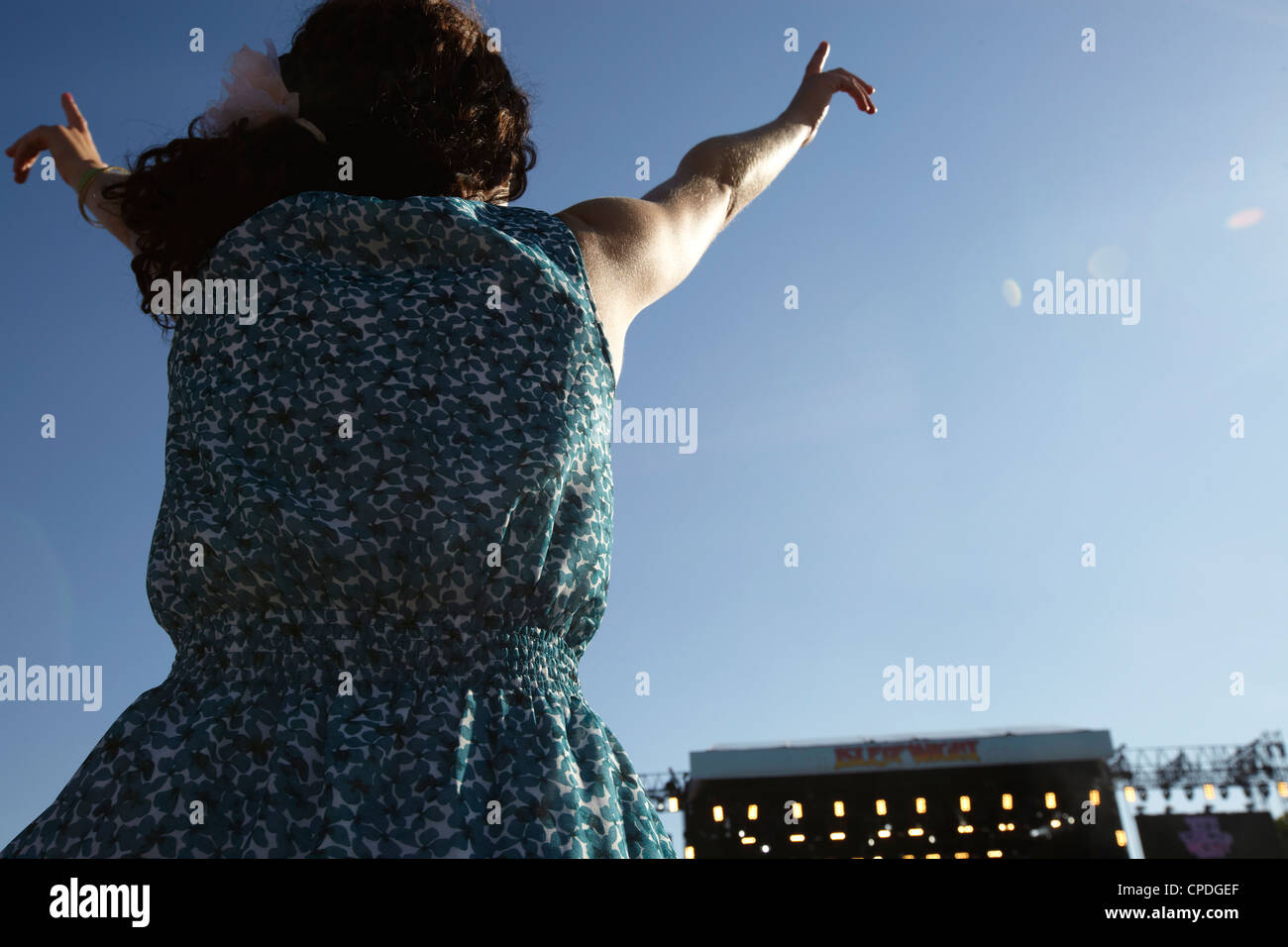 Girl on shoulders cheering in the crowd at gig at a music festival ...