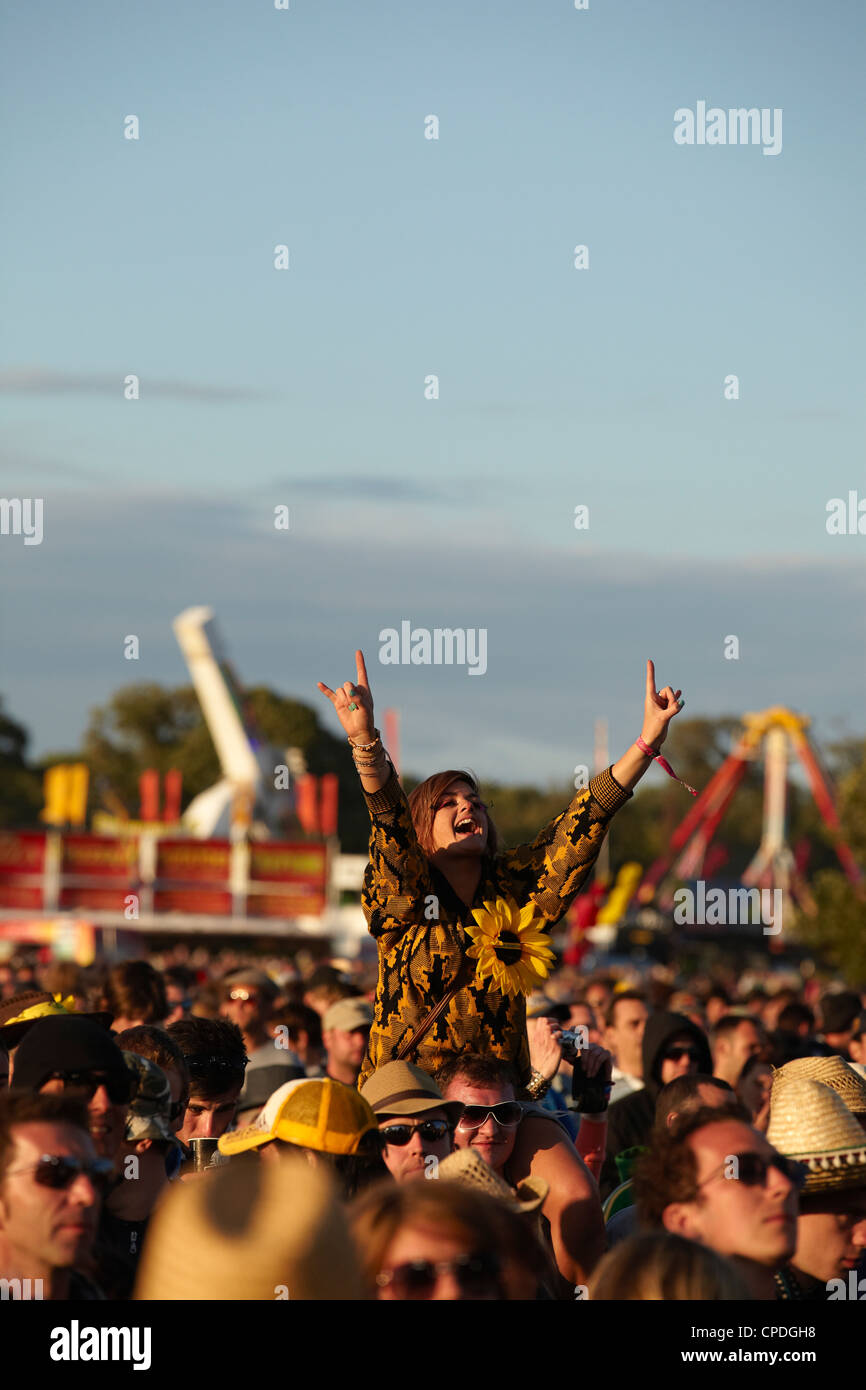 Girl in crowd on shoulders screaming and cheering at a music festival ...
