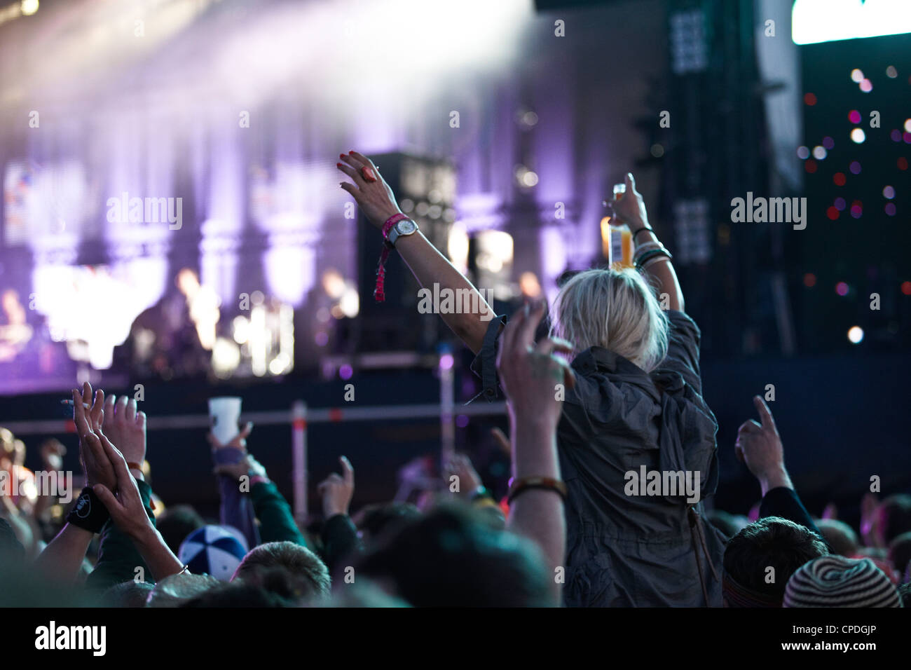 Girl on shoulders at a music festival or gig cheering Stock Photo - Alamy