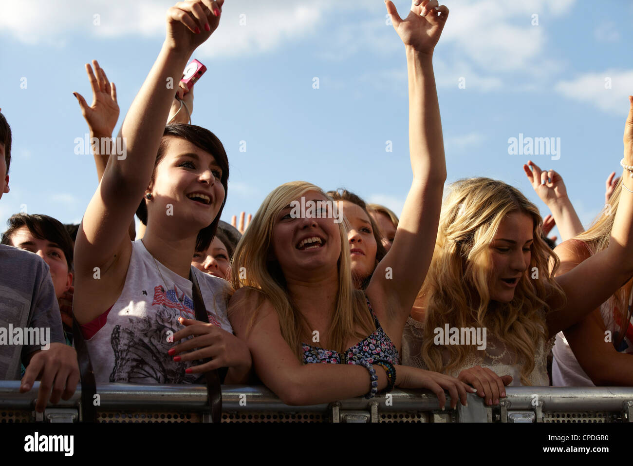 Crowd in the front row at front of the stage at a music festival in the ...
