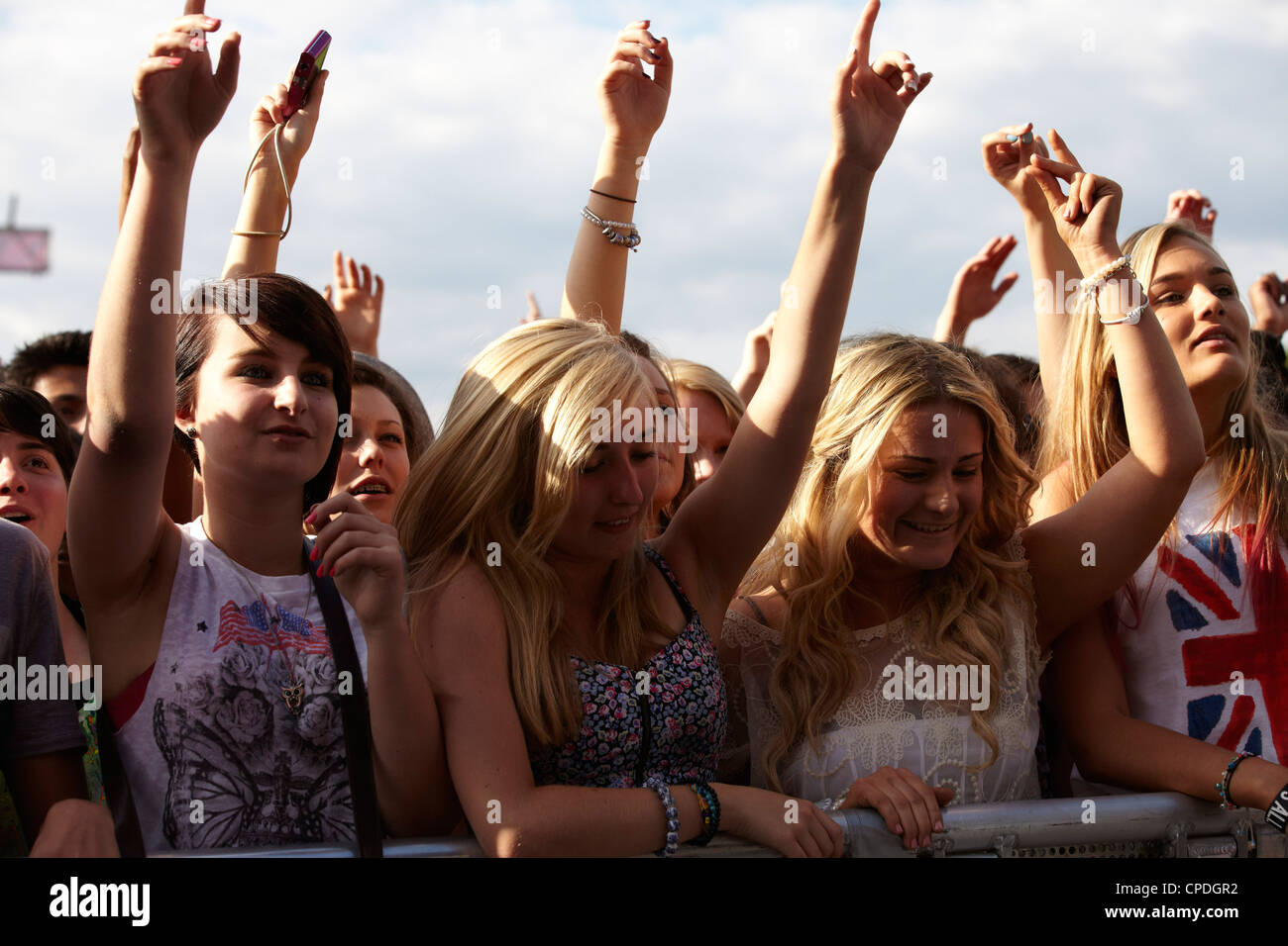 Crowd in the front row at front of the stage at a music festival in the ...