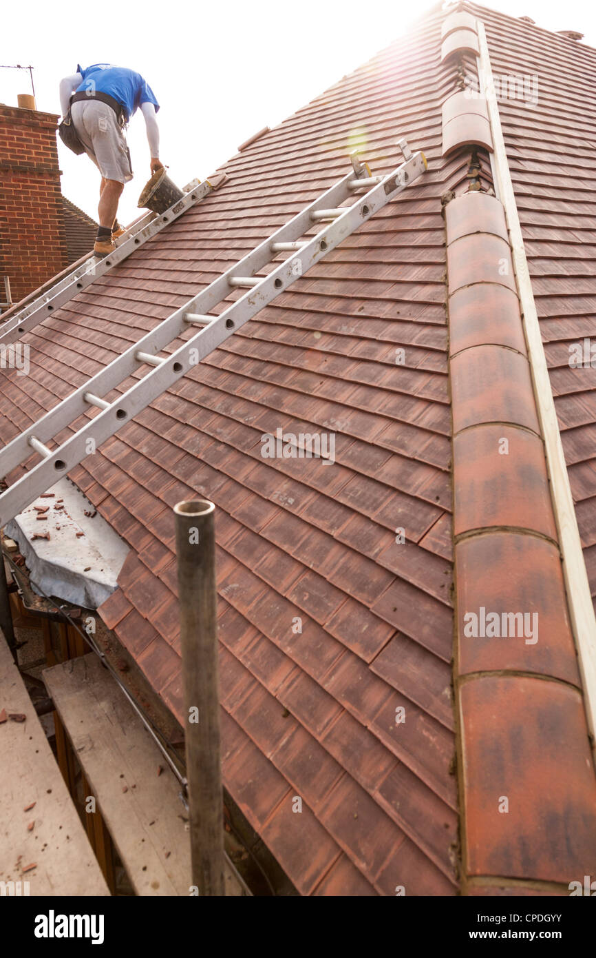 Detached house having tiles striped from roof and replacing with new ...