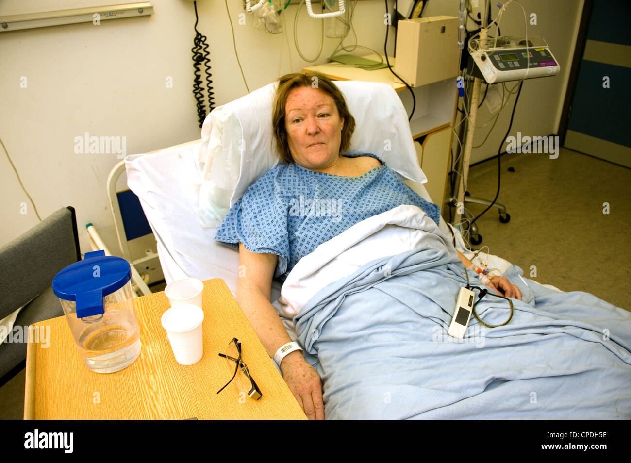 A middle aged woman in a post operation room recovering Stock Photo - Alamy