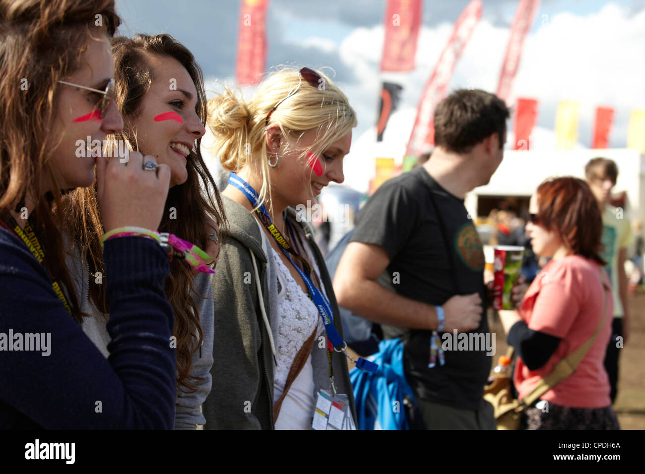 Group of girl friends walking along at a music festival in the summer ...