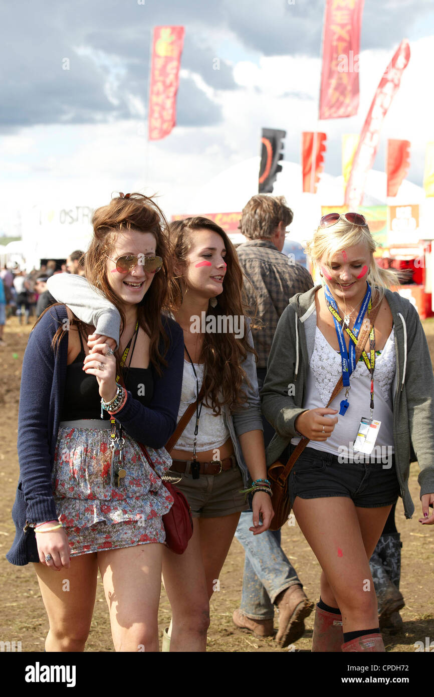 Group of girl friends walking along at a music festival in the summer ...