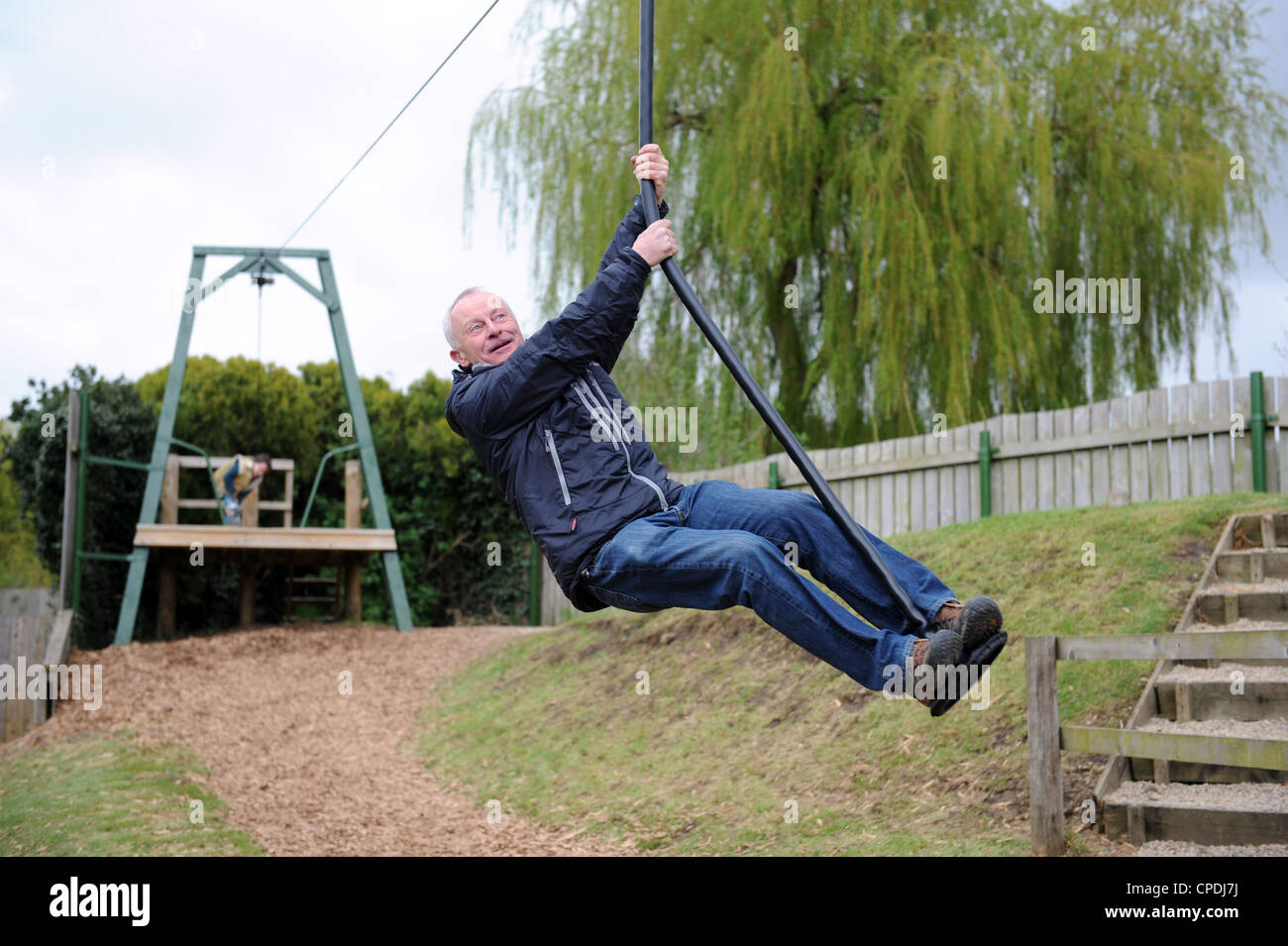 Grown up man pulling funny face on a zipwire at Newby hall in NORTH ...