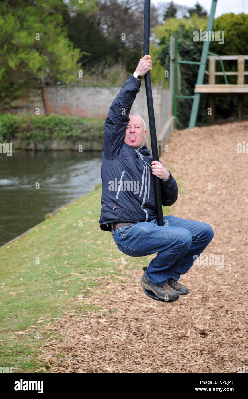 Grown up man pulling funny face on a zipwire at Newby hall in NORTH ...