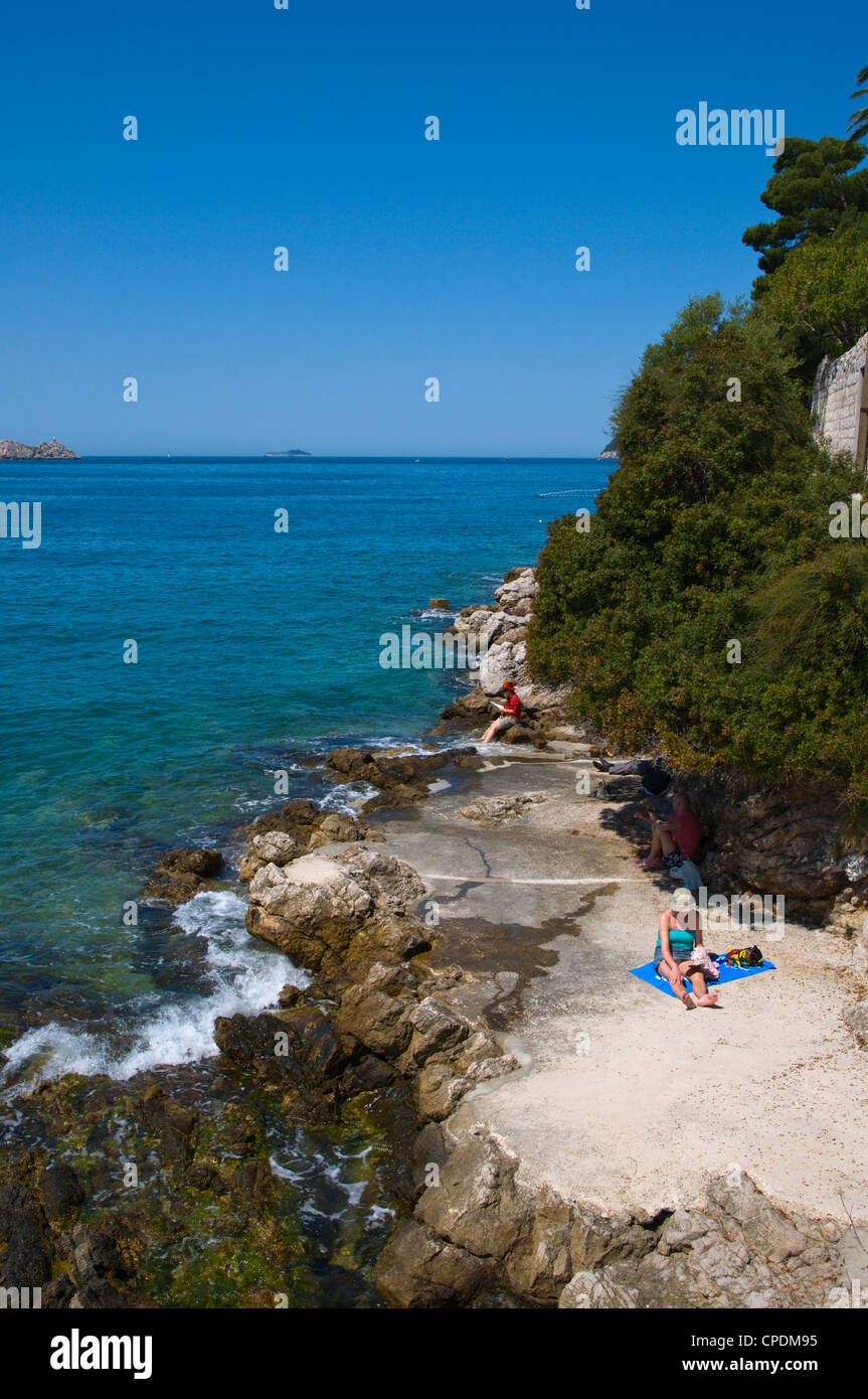 People sunbathing on the rocks Babin Kuk peninsula Dubrovnik city ...
