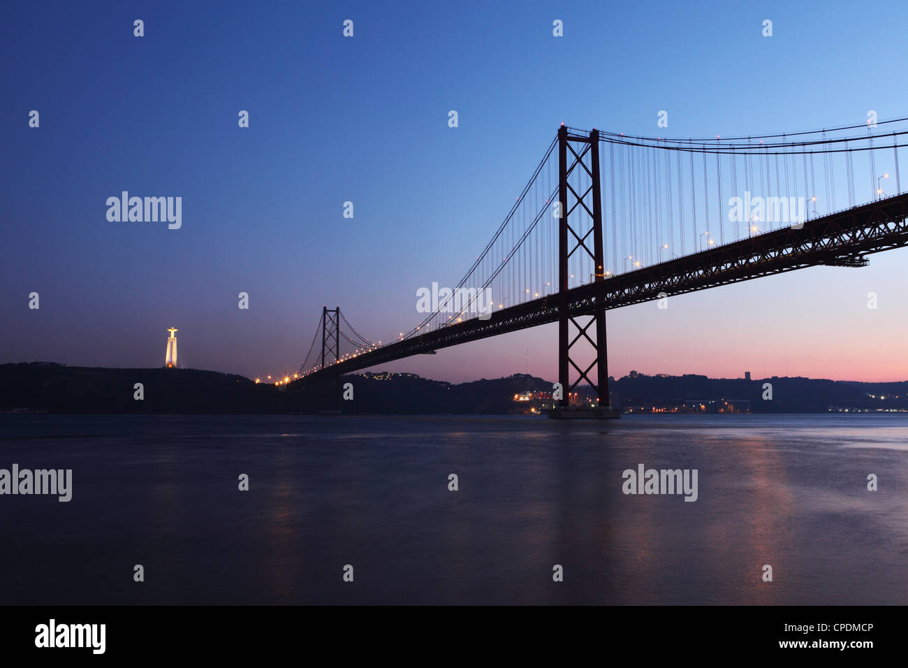 The 25 April Suspension Bridge at dusk over the River Tagus (Rio Tejo ...