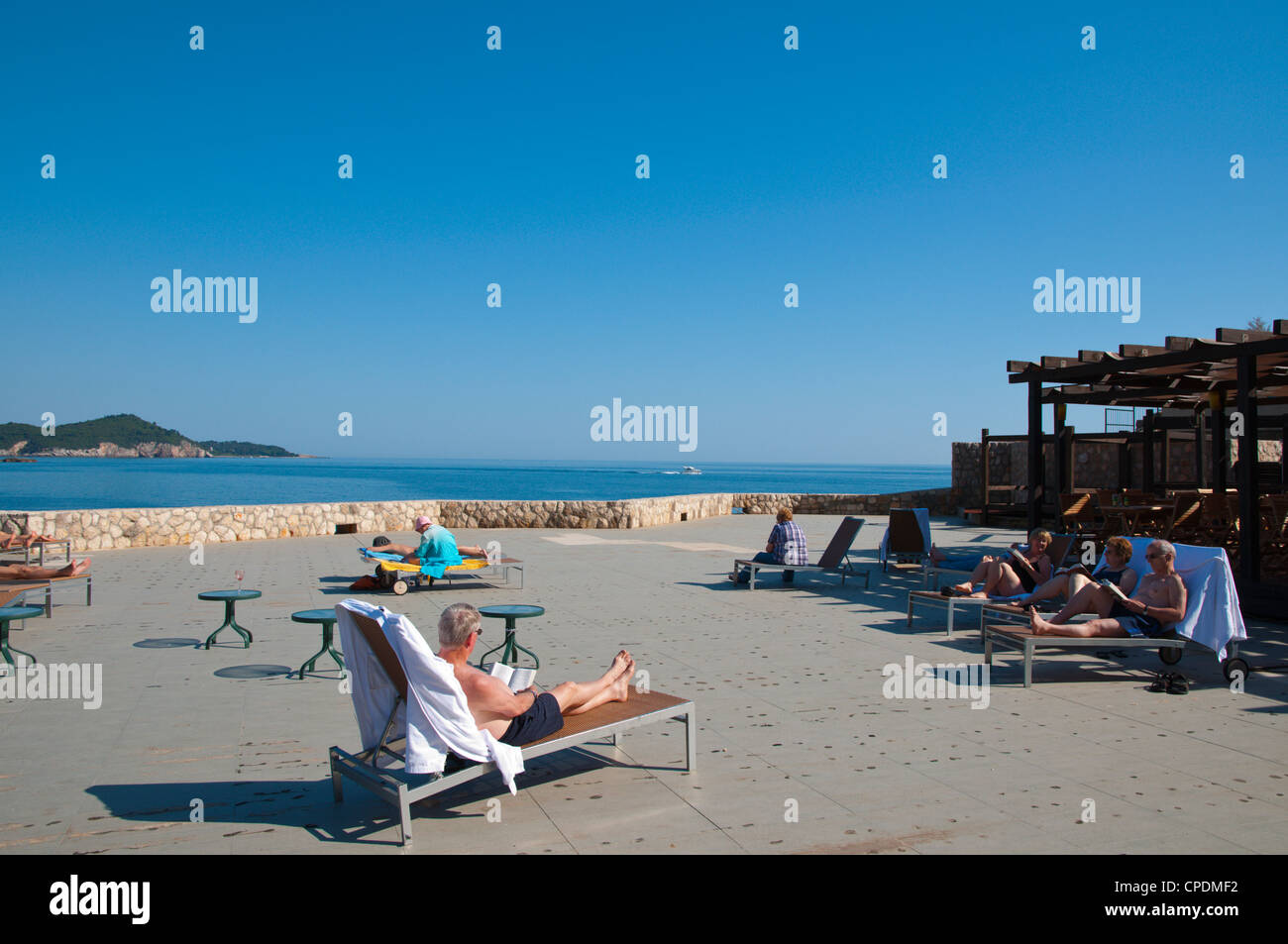 People sunbathing on the seafront terrace of Rixos Libertas chain hotel ...