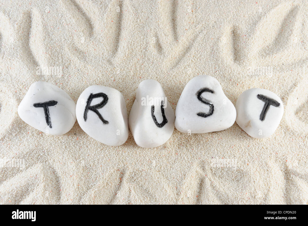 Trust word on group of stones on the sand Stock Photo - Alamy