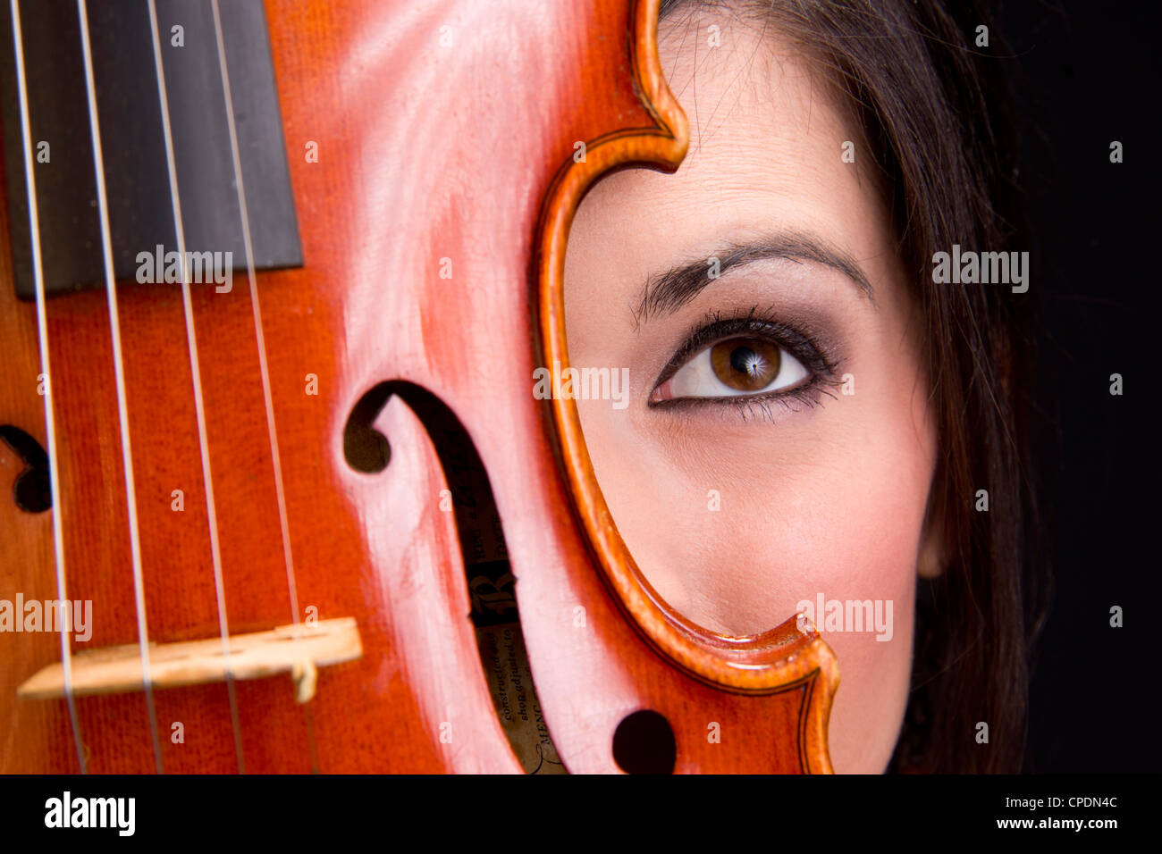A Woman's Face with eye looking up Behind Violin Stock Photo - Alamy